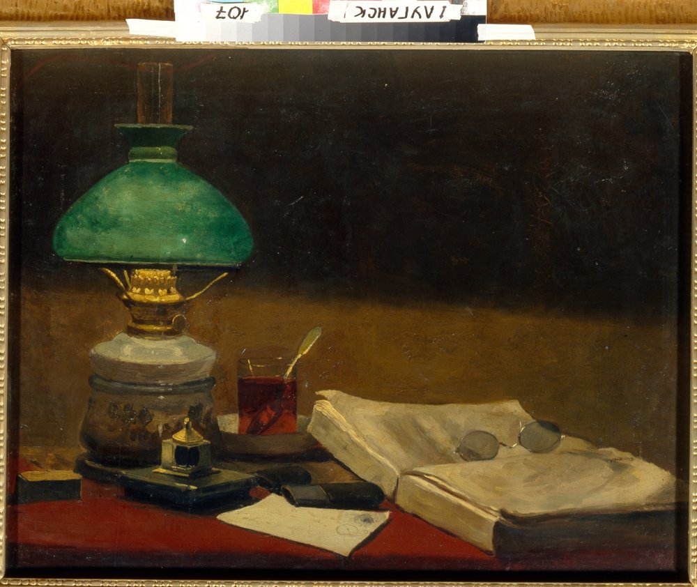 Stillleben mit Buch, Schreibtischlampe, Brille und Teetasse